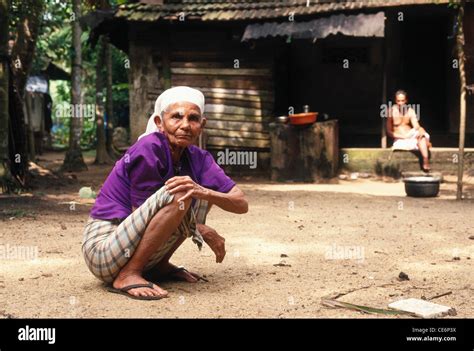 Indian Seniors Rural Woman Sitting Crouching In Front Of Her House