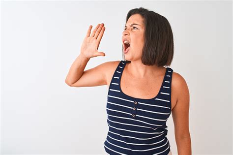 파란색 줄무늬 티셔츠를 입은 젊은 아름다운 여성이 고립된 흰색 배경 위에 서서 입을 다물로 큰 소리로 외치고 비명을 지르고 있습니다 통신 개념입니다 T 셔츠에 대한 스톡