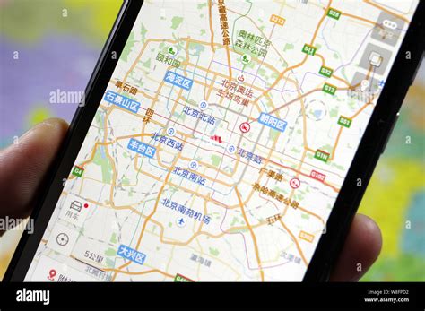 a chinese man uses the baidu map app on his smartphone in jinan city