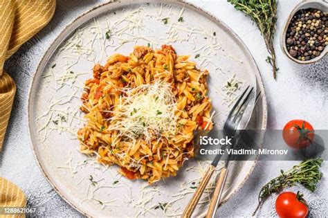 오르조 파스타 볼로네즈 소스를 곁들인 리손 접시에 간 쇠고기 회색 배경 위쪽 보기 0명에 대한 스톡 사진 및 기타 이미지 0