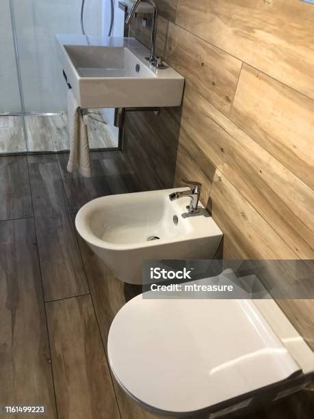 현대 스웨덴 스타일의 보관소 화장실 욕실 스위트 룸 흰색 벽 매달려 화장실 화장실 과 부드러운 닫기 좌석 뚜껑과 일치하는 비데 나무 바닥과 사우나 같은 나무 입은 벽 벽에