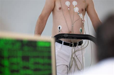 A Middle Aged Man Is Undergoing A Medical Stress Test On A Treadmill Connected To Ecg