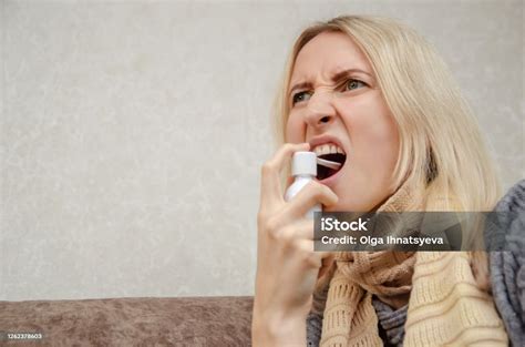 목에 스카프를 두르고 혐오스러운 얼굴을 한 금발 소녀가 목 스프레이를 부어 공간을 복사합니다 의학 건강의 개념 20 29세에 대한 스톡 사진 및 기타 이미지 Istock