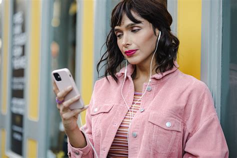 스마트 폰을 사용하고 이동 중에도 인터넷 콘텐츠를 소비하는 특이한 젊은 사람 넌 바이너리 젠더에 대한 스톡 사진 및 기타 이미지 넌 바이너리 젠더 전화 사용