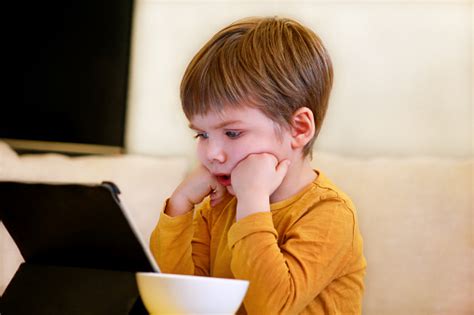 가정에서 침대에 태블릿 Pc를 사용 하는 아이 소파에 귀여운 소년은 만화를 보고 게임을 재생 하 고 노트북에서 학습 교육 재미