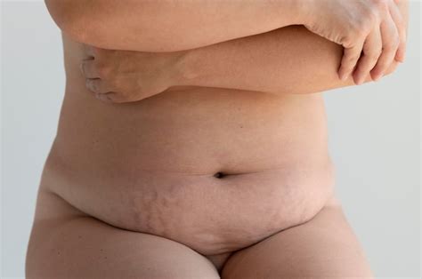 누드에서 자신있게 포즈를 취하고 그녀의 피부를 보여주는 매력적인 여자 무료 사진