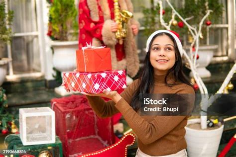 쾌활 한 미소 젊은 여자가 선물 상자를 들고 크리스마스 축제를 즐기고 있습니다 12월에 대한 스톡 사진 및 기타 이미지 12월 20 24세 2024년 Istock