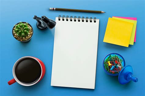 컵 커피 식물 편지지 및 사무실의 사무실 테이블에 노트북을 제공합니다 빈 메모장 입력된 복사 또는 텍스트에 대 한 종이입니다 상위 뷰 책상 평면 파란색 배경 개념을 하다 0