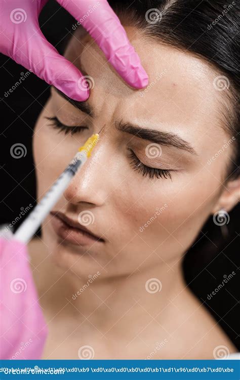 Beautician Is Injecting Botulinum Toxin To Correct Mimic Wrinkles And Beautician Is Injecting Botulinum Toxin To Correct Mimic Wrinkles And