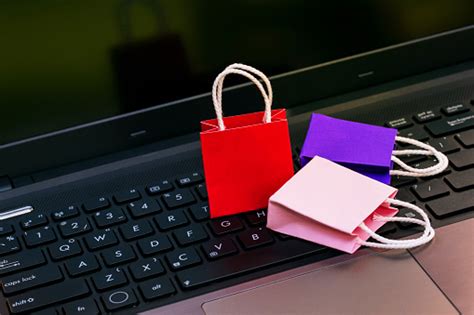 노트북 키보드에 작고 다채로운 종이 쇼핑 가방 온라인 쇼핑에서 홈 쇼핑 또는 사무실 고객 항목 또는 서비스 또는 상품 원격으로 구입할 수 있습니다에 대 한 아이디어 가방에