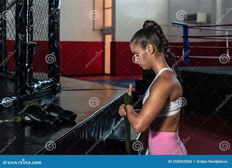 Young Boxer Woman Puts Protective Bandages On Her Hands For Box