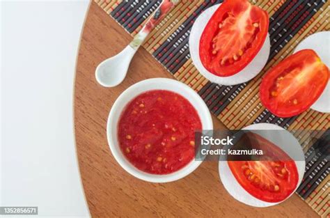 작은 흰색 그릇과 면 패드에 신선한 토마토 퓌레 수제 얼굴 또는 아이 마스크 천연 뷰티 트리트먼트 및 스파 레시피 상단 보기