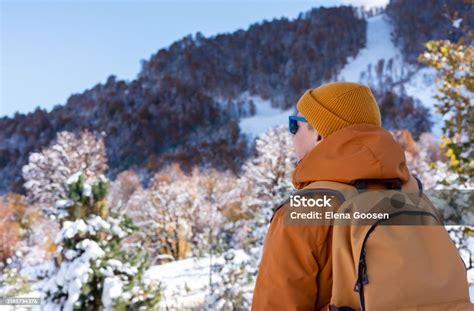 빨간 생강 재킷과 노란 배낭을 쓴 모자를 쓴 남자의 뒷모습 가을 겨울 숲 풍경과 함께 아름다운 산의 경치를 바라 보는 하이킹 및 관광 40 44세에 대한 스톡 사진 및 기타