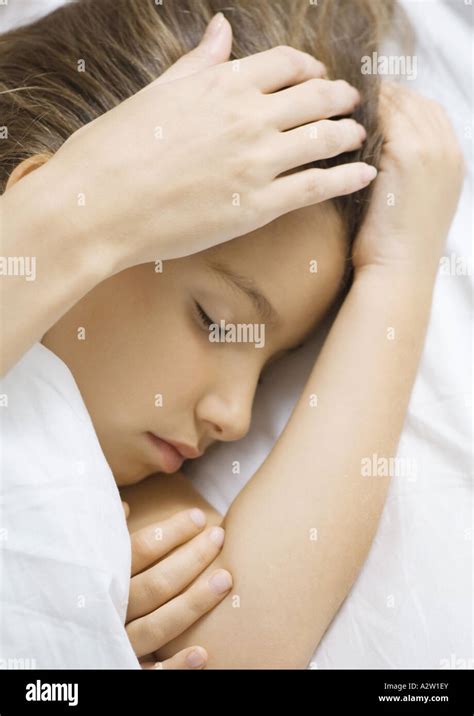 Girl Sleeping In Bed Mother S Hand Stroking Head Stock Photo Alamy