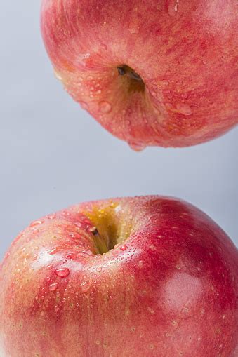 밝은 배경에 놓인 피부에 물방울이 있는 신선한 빨간 사과의 클로즈업으로 건강한 열대 과일의 과즙 질감 수분 공급 및 자연스러운