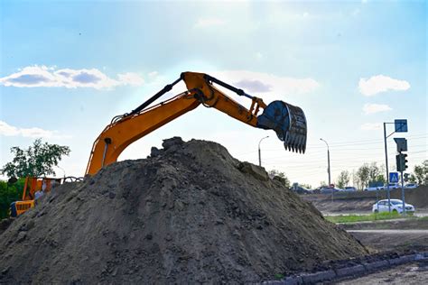 푸른 하늘 배경에 열린 구덩이에서 토공 중 굴삭기 작업 현장에서 화물의 굴착 적재 리프팅 및 운반을 위한 건설 기계 및 토공 중장비 0명에 대한 스톡 사진 및 기타 이미지