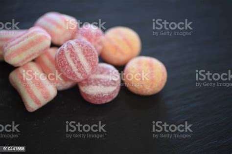 분홍색과 흰색 줄무늬 검은 맛 사탕 과자 설탕 코팅 과일의 음식 사진 가까이 슬레이트 또는 돌 Constrasting 배경 및 오버 헤드 보기 0명에 대한 스톡 사진 및