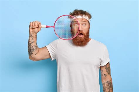 Free Photo Horizontal Shot Of Scared Red Haired Tennis Player Holds Racket While Posing