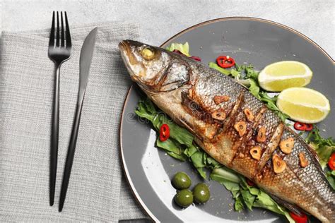 Delicious Sea Bass Fish And Ingredients Served On Light Grey Table