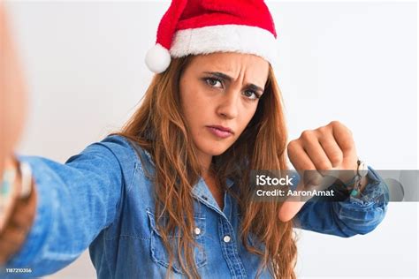 크리스마스 모자를 쓰고 화가 난 얼굴로 셀카를 찍고 엄지 손가락으로 싫어하는 것을 보여주는 부정적인 표지판 거부 개념 개념에 대한 스톡 사진 및 기타 이미지 Istock