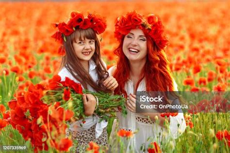 흰색 드레스와 화환에 빨간 머리 어머니와 어린 소녀는 여름 일몰에 양귀비 필드에 양귀비의 꽃다발과 함께 포즈 가족에 대한 스톡 사진 및 기타 이미지 Istock