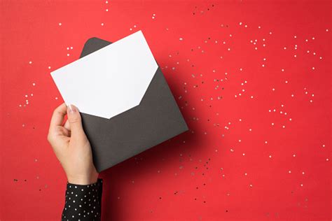 색종이가 있는 빨간 배경에 카드가 달린 검은 봉투를 들고 있는 여성의 손 사진 위에 있는 1인칭 보기 개념에 대한 스톡 사진 및 기타 이미지 Istock