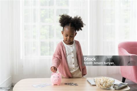 저축과 은행 돈 개념 돼지 저금통에 돈을 넣는 여자 아이 돼지 저금통에 동전을 넣는 아프리카계 미국인 소녀 아이 미래 개념에 대한 아이 투자 2 3 살에 대한 스톡 사진 및