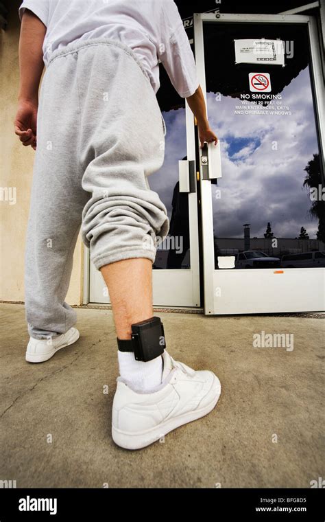 Wearing An Electronic Ankle Monitor A Teenage Offender Enters A County