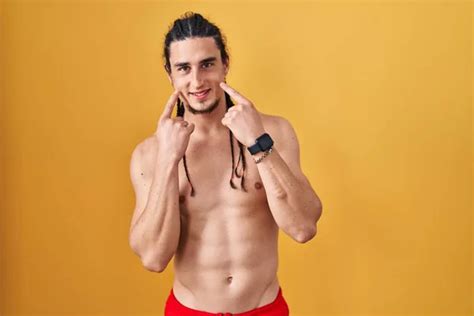 Hispanic Man Long Hair Standing Shirtless Yellow Background Showing