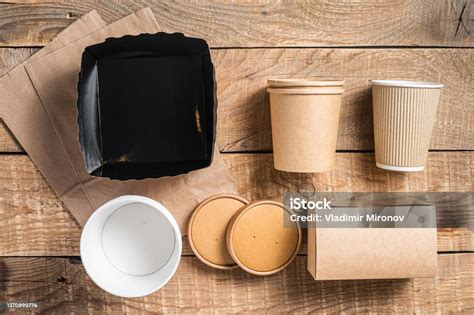 일회용 종이 식기 종이 컵 접시 가방 패스트 푸드 용기 및 칼붙이의 친환경 재활용 세트 나무 배경 맨 위 보기입니다 복사 공간
