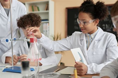 Side View Smiling Black Schoolgirl Doing Science Experiment In School