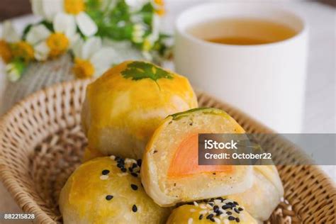 맛 있는 중국 생 과자 또는 달 케이크 녹두 풀으로 가득 소금에 절인 계란 노 른 자 쪽 보기에서 나무 테이블에 차를 곁들여 나무 바구니에 가까이 수 제 베이커리 개념입니다