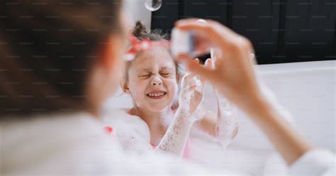젊은 어머니 여자와 작은 트윈 소녀 딸이 집에서 거품으로 목욕에서 재미를 느낀다 사진 Unsplash의 욕조 이미지
