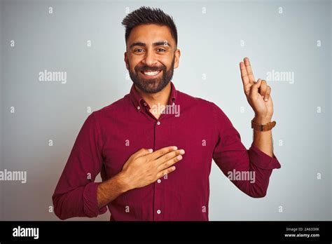 Young Indian Man Wearing Red Elegant Shirt Standing Over Isolated Grey