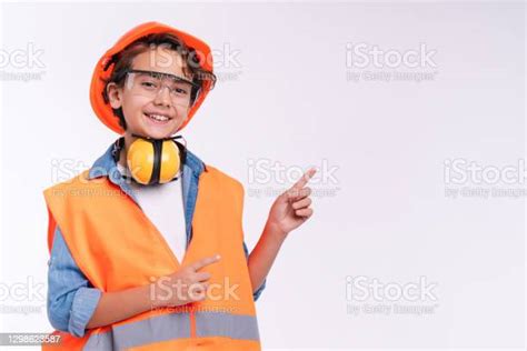 흰색 배경 위에 고립 된 복사 공간을 가리키는 유니폼을 입은 작은 백인 소년 건설 노동자 10 11세에 대한 스톡 사진 및 기타 이미지 10 11세 가리키기 건설