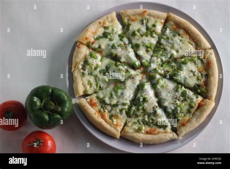 Home Baked Veg Pizza With Cheese And Capsicum Shot On White Background