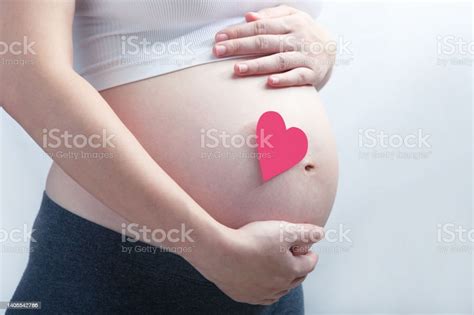 그녀의 아기 범프에 단일 분홍색 심장을 가진 임산부 모두 흰색 배경에 있습니다 35 39세에 대한 스톡 사진 및 기타 이미지 35 39세 가족 감정 Istock