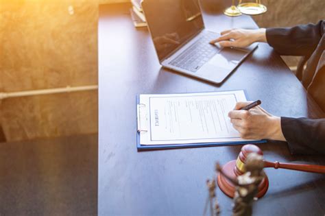 계약서를 손에 들고 법률에 따라 사업을 운영하기 위해 법률 자문이 필요한 사업가 팀을 위한 컨설팅 계약에 서명할 준비를 하는 변호사 결정에 대한 스톡 사진 및 기타 이미지