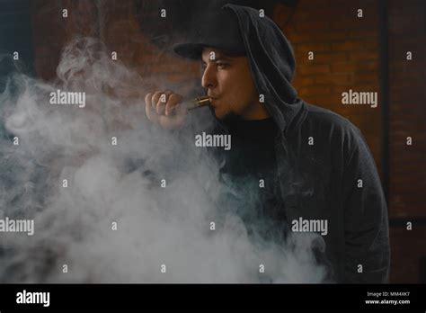 A Cloud Of Vapor Vaping Man Holding A Mod Brick Background Vape