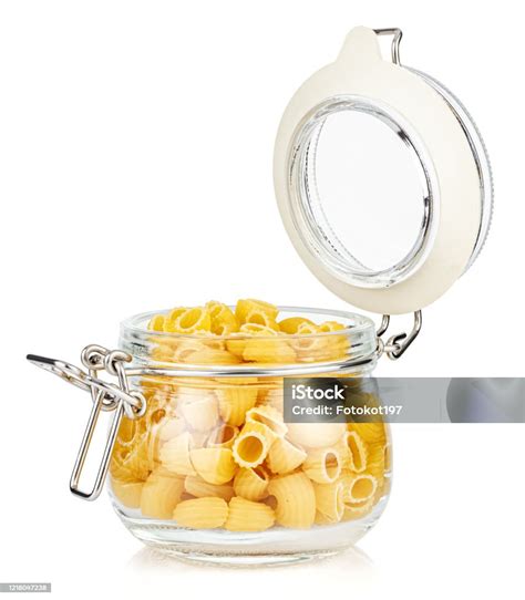 흰색 배경에 분리 된 뚜껑에 고무 씰과 금속 클램프가있는 열린 투명 유리 항아리에 말린 이탈리아 파스타 달팽이 파이프 Rigate 건강한 생활방식에 대한 스톡 사진 및 기타
