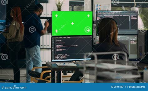 Software Developer Analyzing Greenscreen And Server Code On Multiple Monitors Stock Image