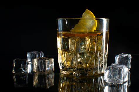반사가 있는 검은 테이블에 레몬 조각을 얹은 얼음이 있는 위스키 한 잔 검은 색 배경에 0명에 대한 스톡 사진 및 기타 이미지