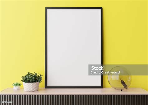 현대 거실의 노란색 벽에 빈 수직 사진 프레임 미니멀하고 현대적인 스타일로 인테리어를 모의하세요 사진 포스터를 위한 여유 공간 콘솔 램프 3d 렌더링 뷰를 닫습니다 3차원