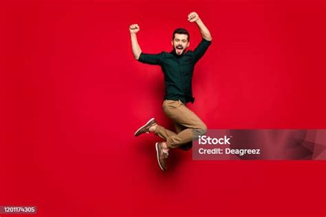 전체 길이 사진 O0f 기쁘게 남자 축하 복권 승리 점프 상승 주먹 비명 예 붉은 색 배경을 통해 고립 된 갈색 바지 바지를 착용 남자에 대한 스톡 사진 및 기타 이미지
