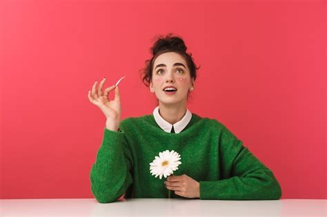 Premium Photo Pretty Nerd Girl Sitting At The Table Isolated Holding Camomile