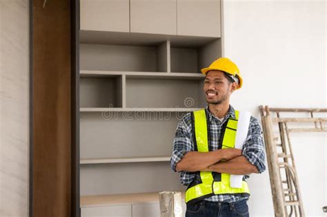 Portrait Of Young Male Engineer Contractor In Work Clothes Standing At