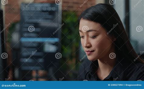 focused asian software developer writing programming code and smiling