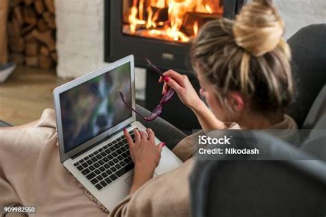 벽난로 옆 아름 다운 중 년 여자는 거실에서 편안 하 고 집에서 랩톱에서 작동 가을에 대한 스톡 사진 및 기타 이미지 가을 거실 겨울 Istock
