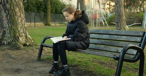 Teen Schoolgirl Does Literature Class Homework When Sitting Outdoors On