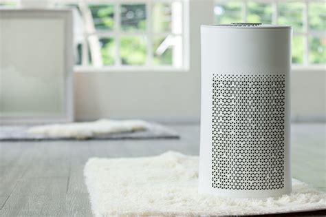 신선한 공기와 건강한 생활을 위해 집에서 먼지 Pm25 Hepa를 제거하는 필터 및 청소를위한 아늑한 흰색 거실의 공기 청정기 공기 오염 개념 공기청정기에 대한 스톡 사진